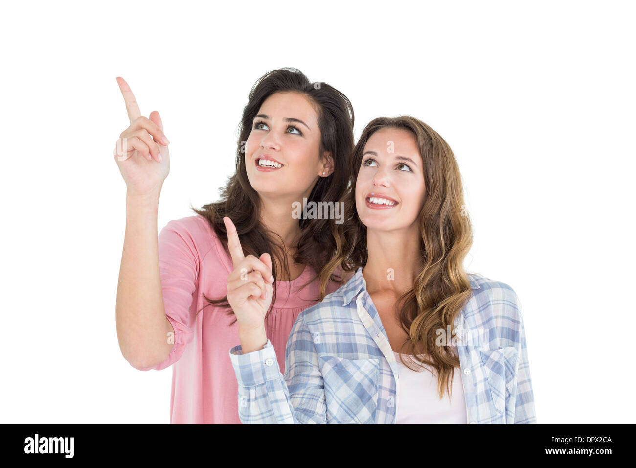 Friends pointing up against white background Stock Photo - Alamy