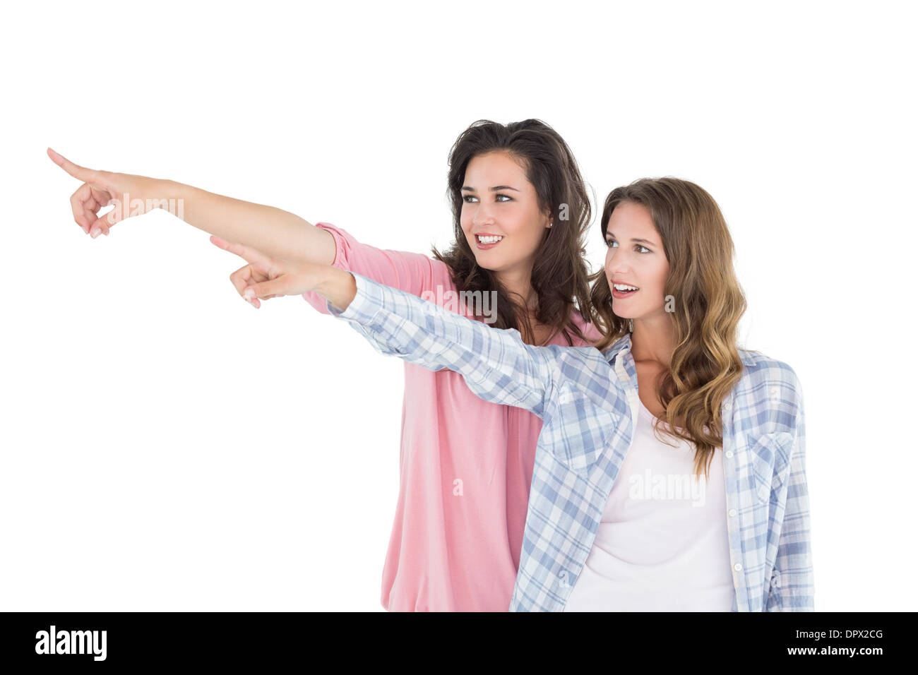 Friends pointing away against white background Stock Photo - Alamy