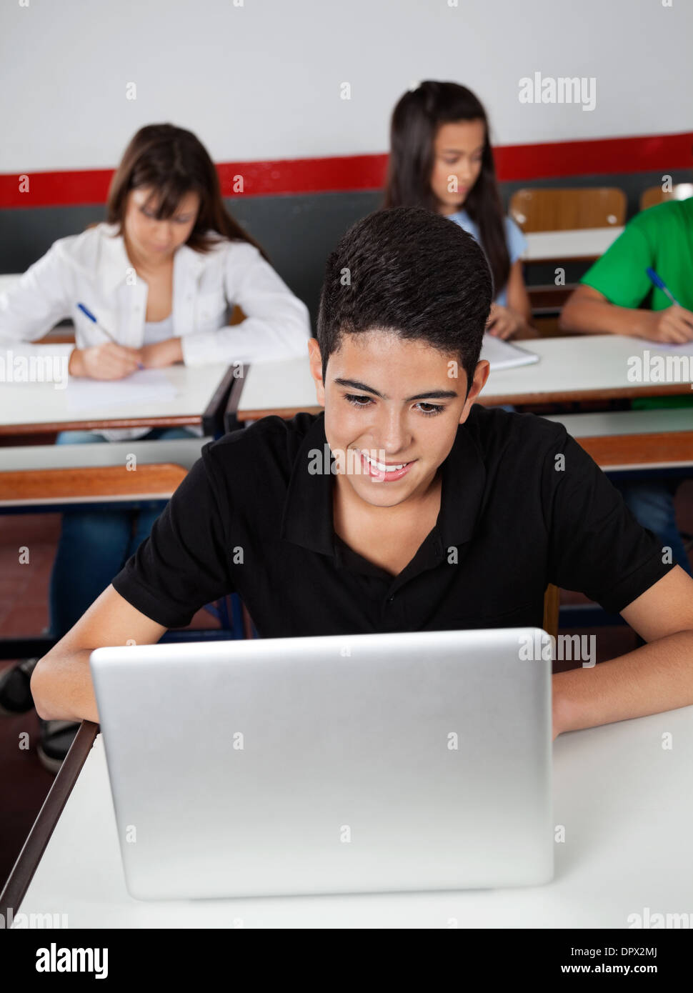 Happy Teenage Schoolboy Using Laptop Stock Photo - Alamy