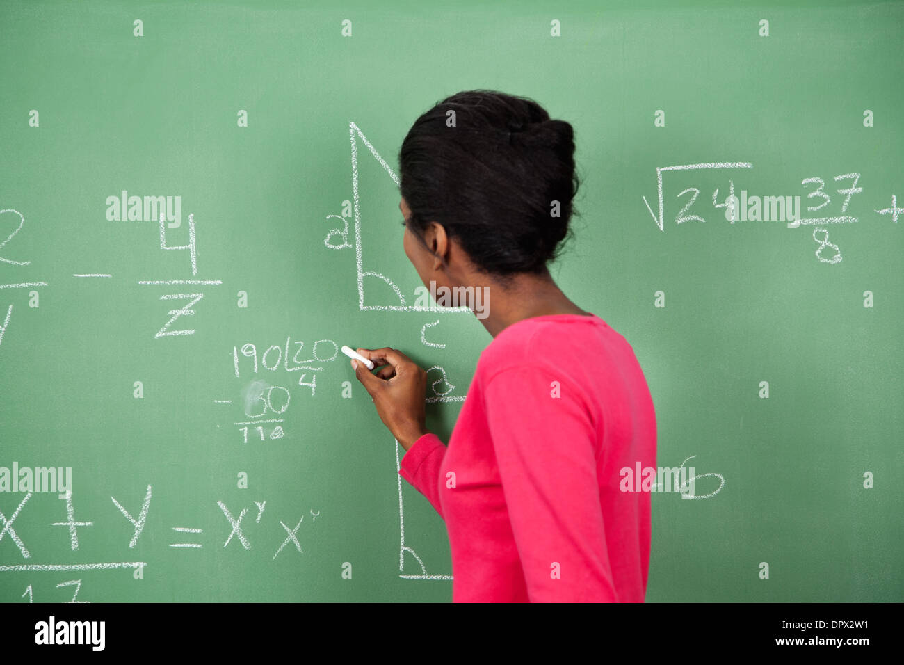 Female Teacher Solving Mathematics On Board Stock Photo - Alamy