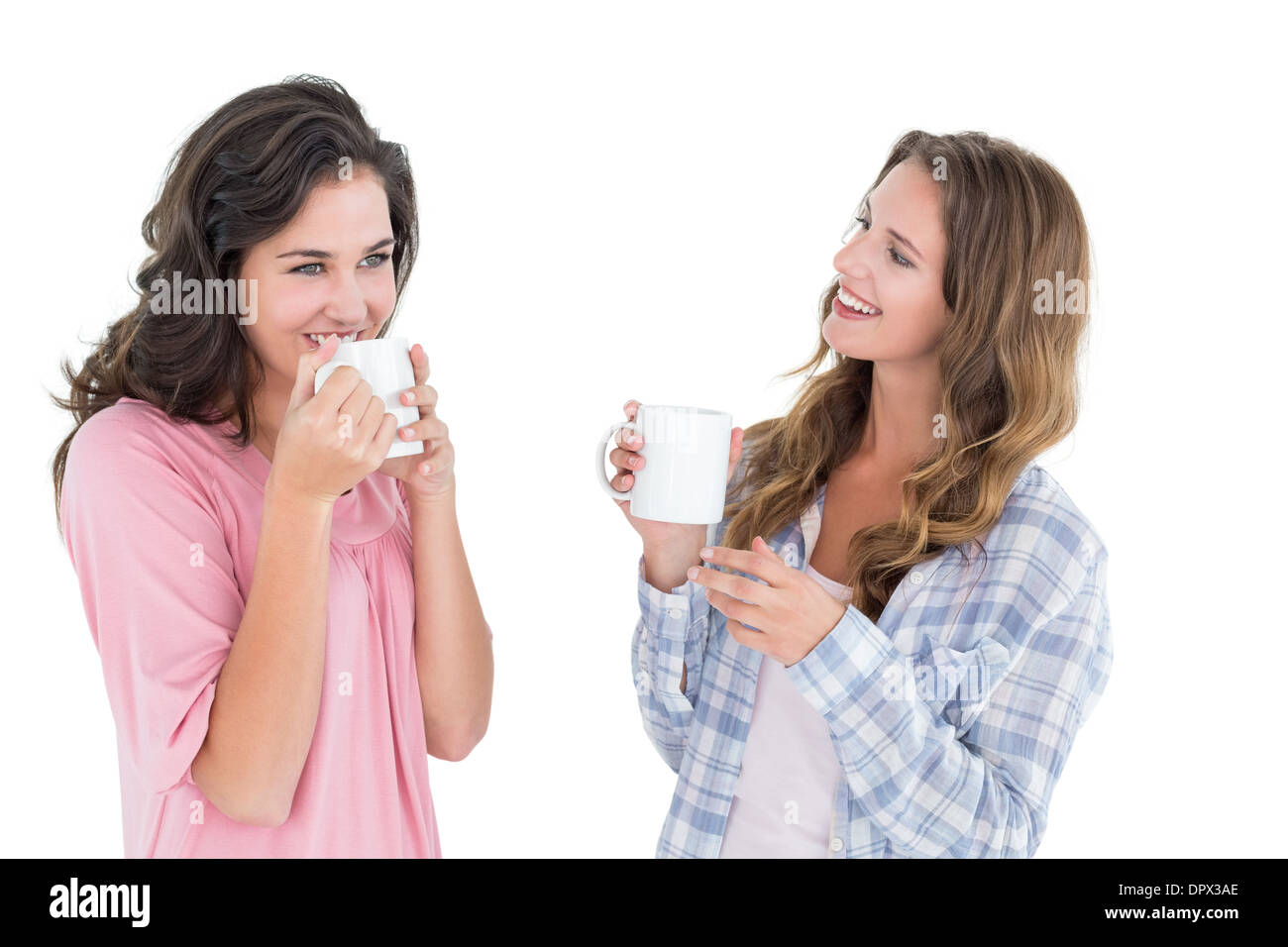 Two smiling young female friends drinking coffee Stock Photo - Alamy