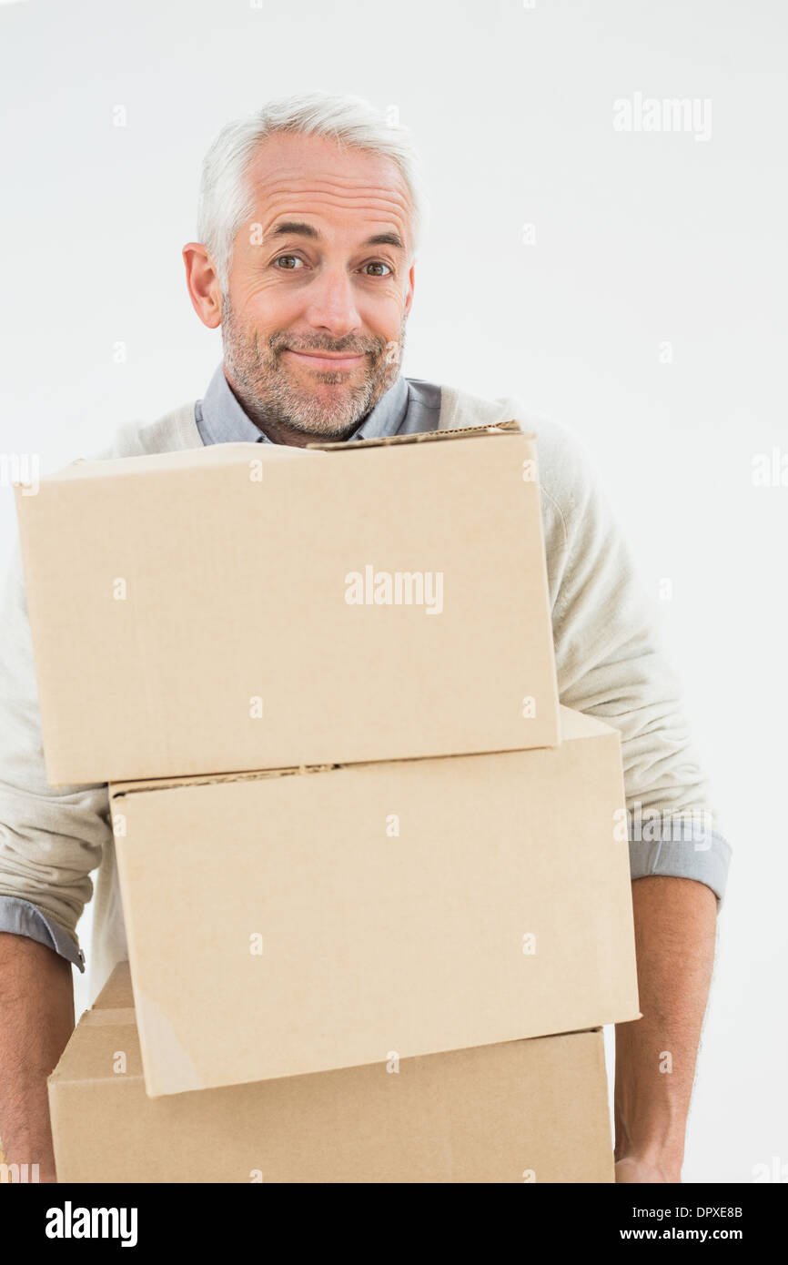 Portrait of a smiling mature man carrying boxes Stock Photo - Alamy