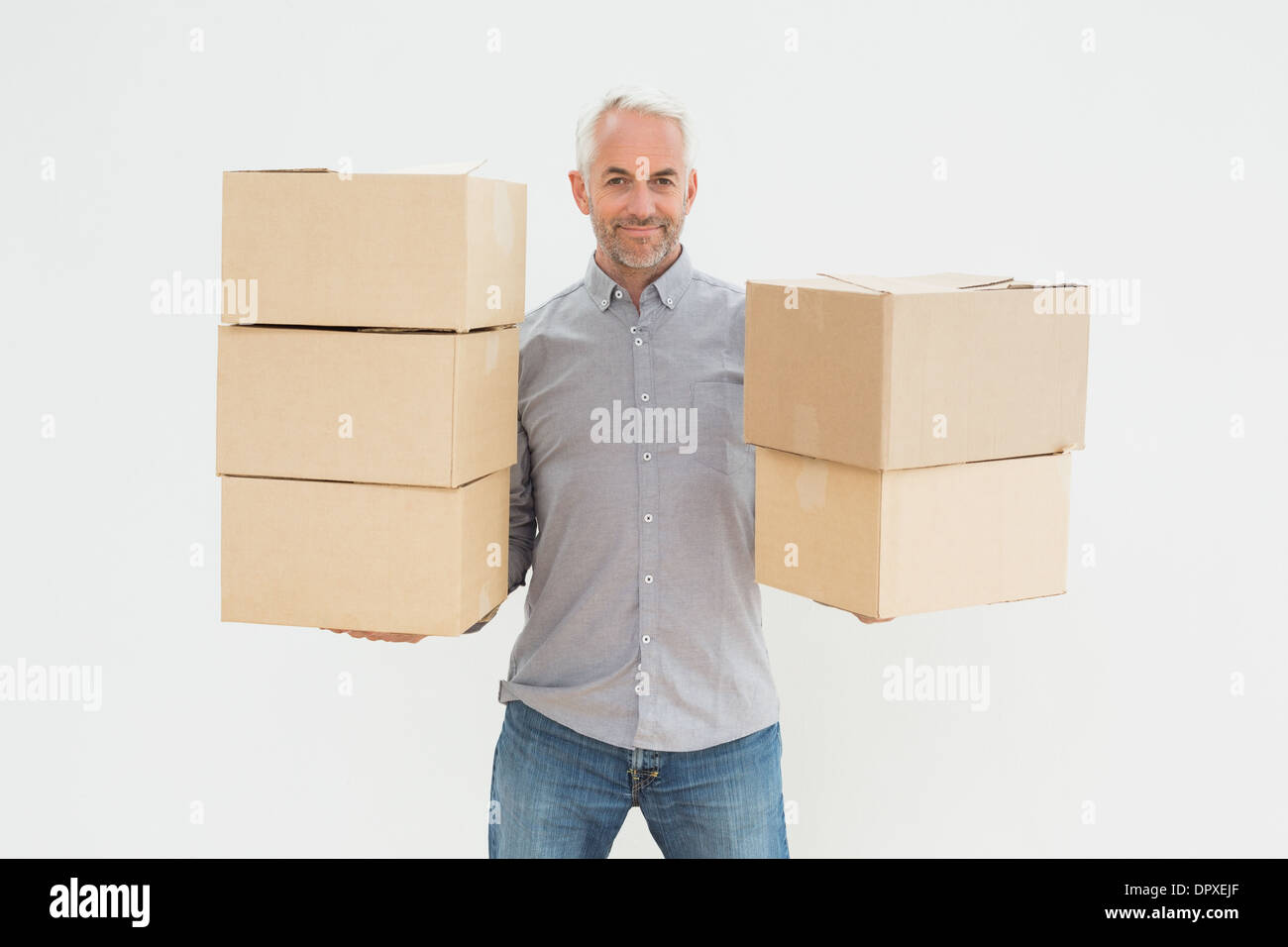 Portrait of a smiling mature man carrying boxes Stock Photo - Alamy