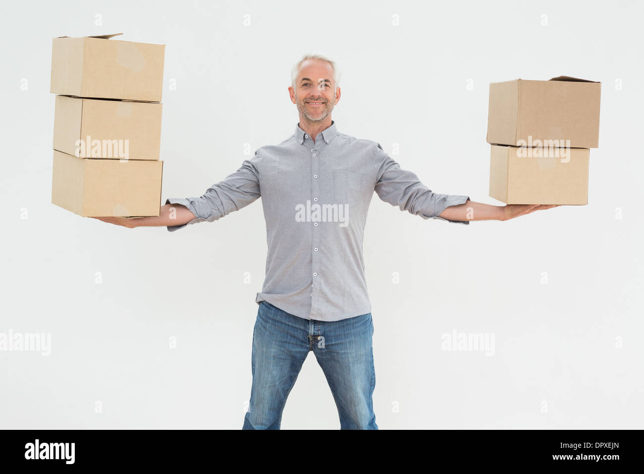 Portrait of a smiling mature man carrying boxes Stock Photo - Alamy