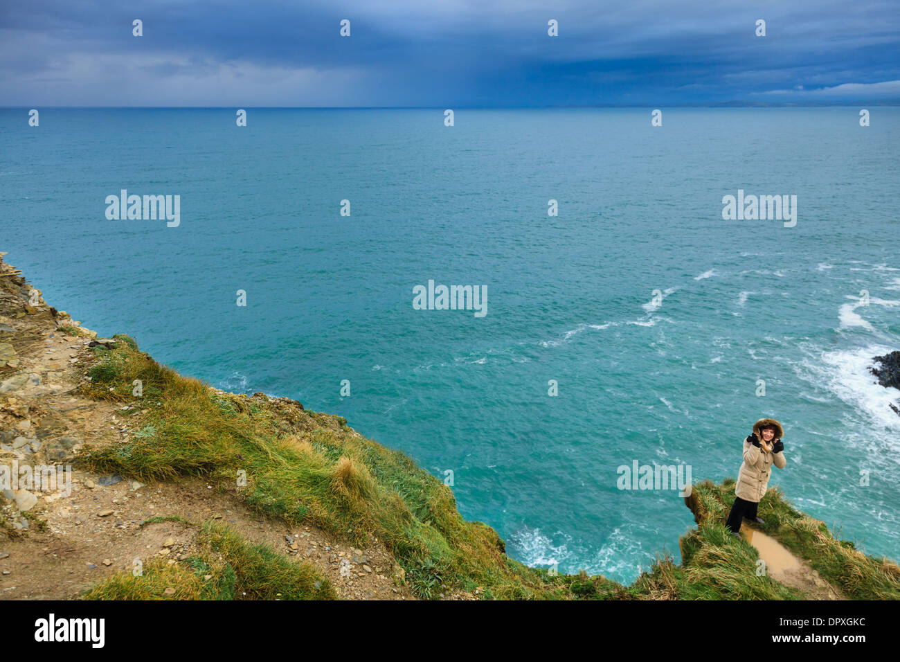 Irish atlantic coast. Woman tourist standing on rock cliff by the ocean ...