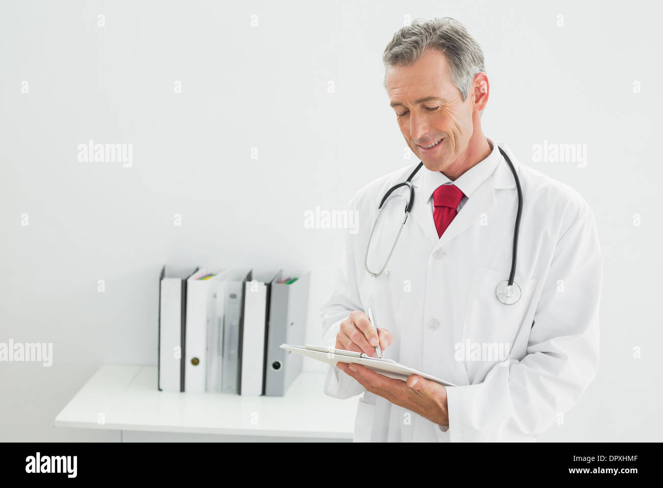 Doctor writing a report at the office Stock Photo - Alamy