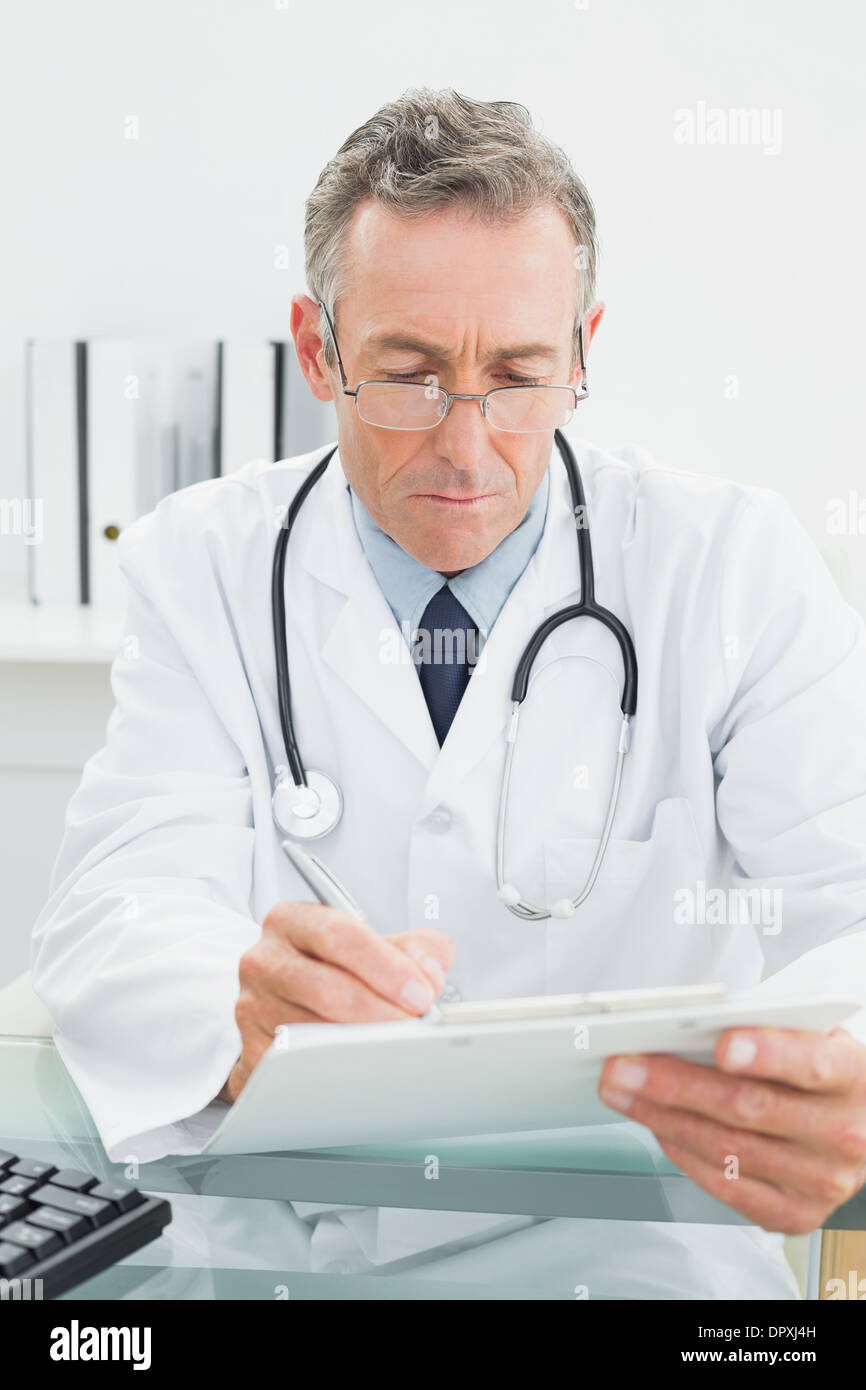 Doctor writing in medical report hi-res stock photography and images ...