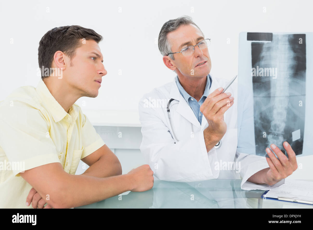 Doctor explaining spine x-ray to patient in office Stock Photo - Alamy