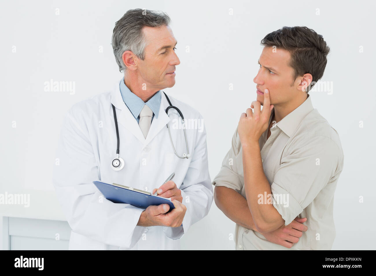 Doctor discussing reports with patient in office Stock Photo - Alamy