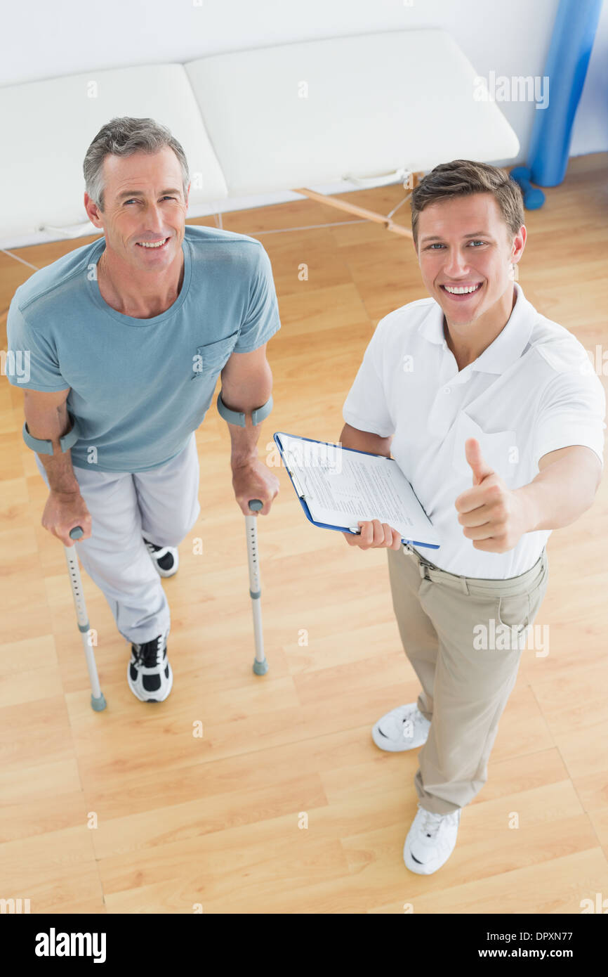 Therapist gesturing thumbs up with disabled patient Stock Photo - Alamy