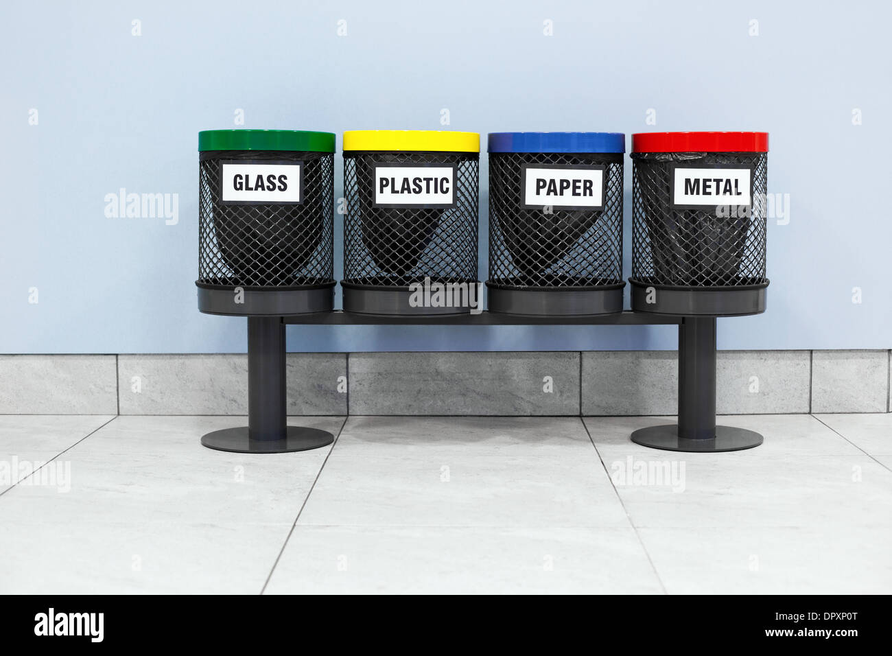 Four garbage bins on wall background Stock Photo - Alamy