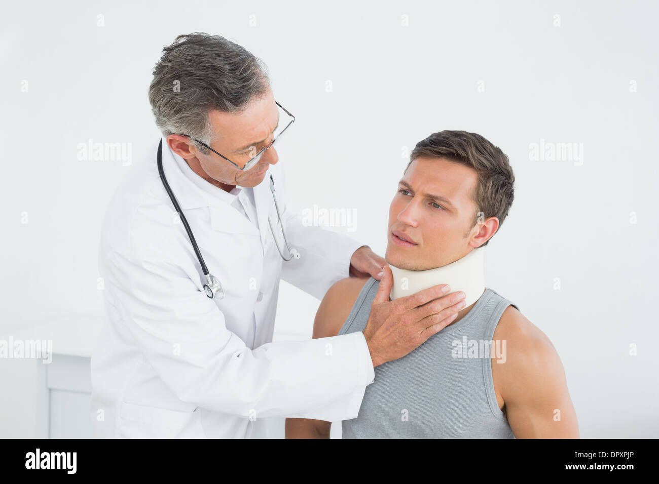 Doctor examining a patients neck in office Stock Photo - Alamy