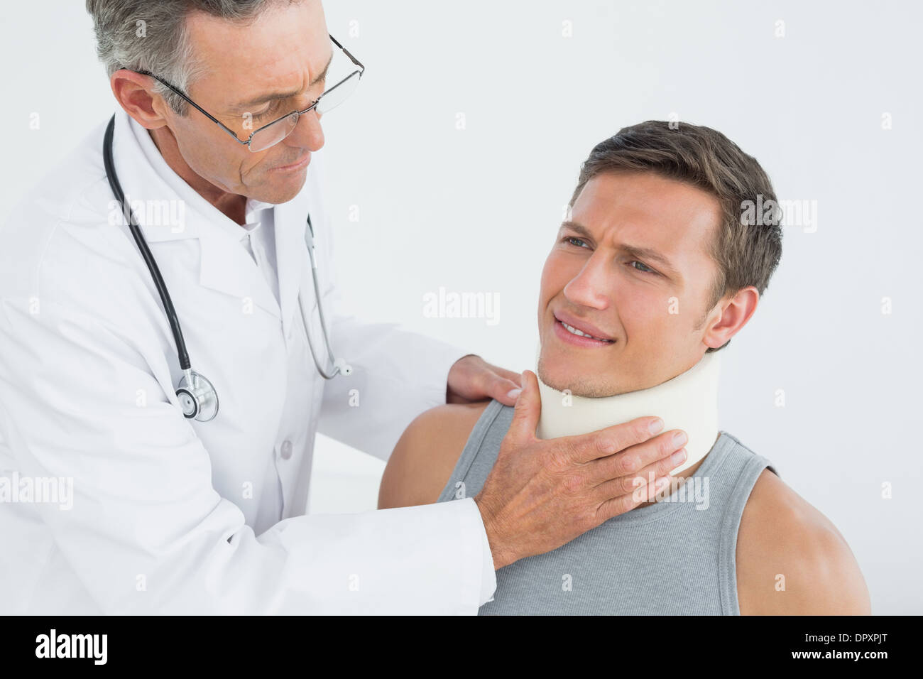 Male doctor examining a patients neck Stock Photo - Alamy