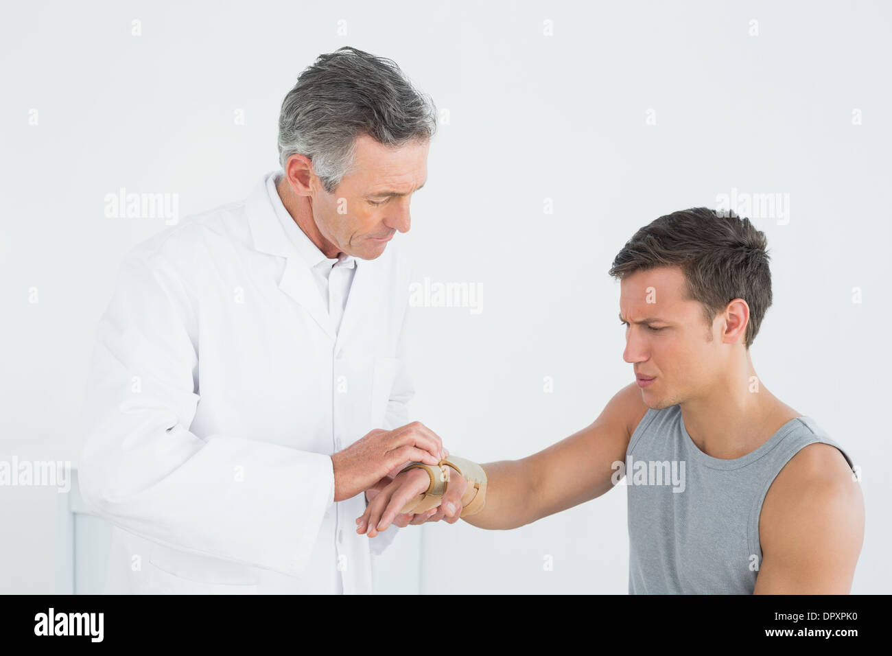 Male doctor examining a patients hand Stock Photo - Alamy