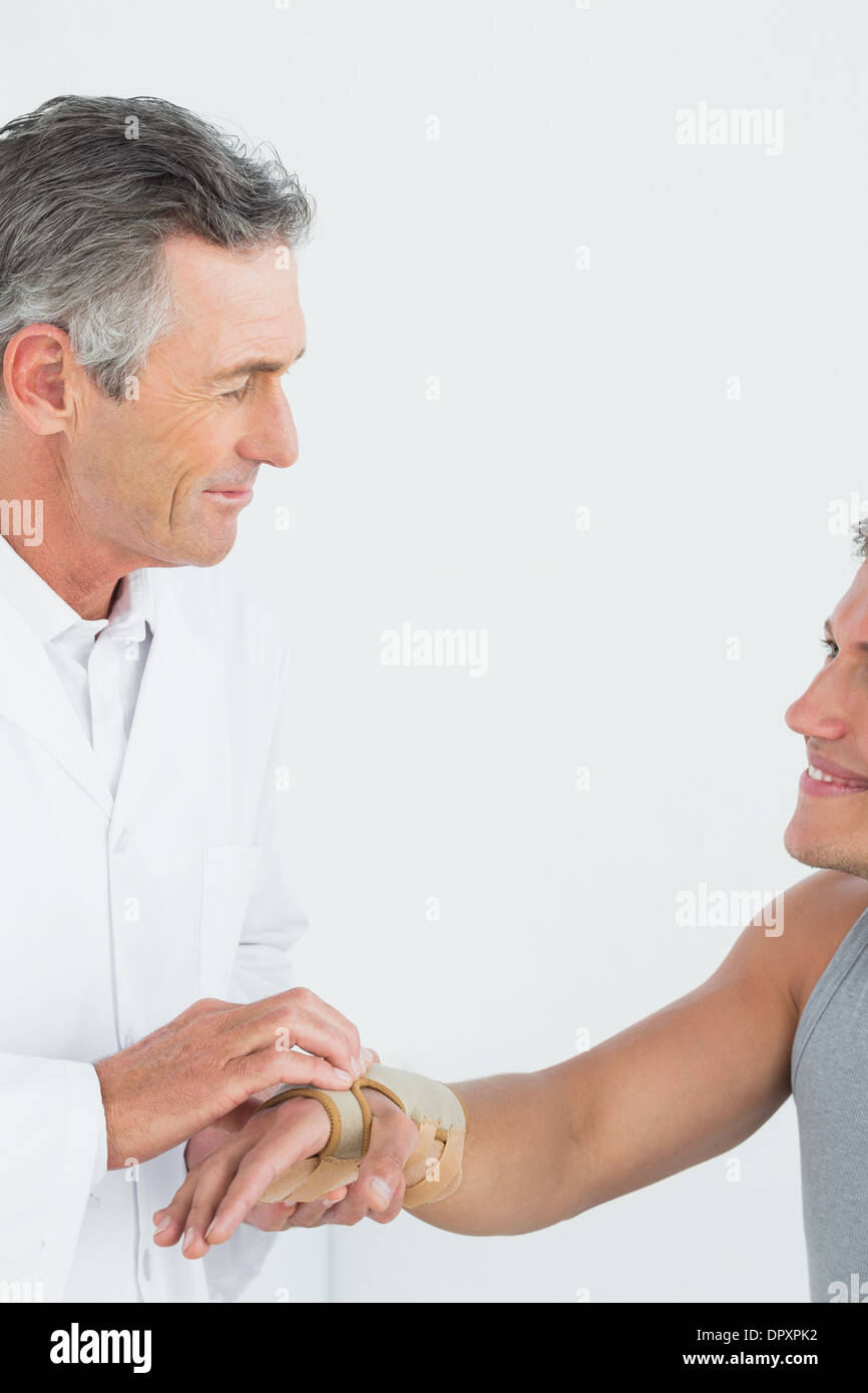 Male doctor examining a patients hand in the medical office Stock Photo ...