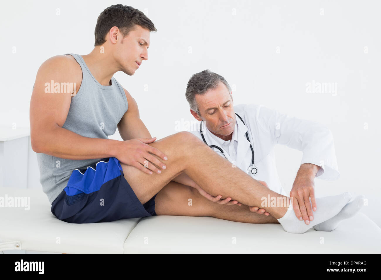 Side view of a young man getting his leg examined Stock Photo - Alamy