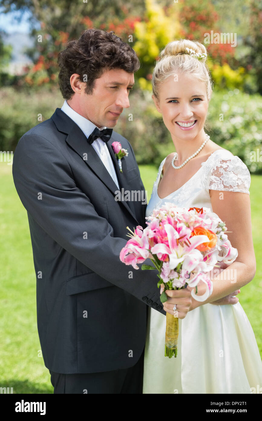 Newlyweds hugging each other bride looking at camera Stock Photo - Alamy