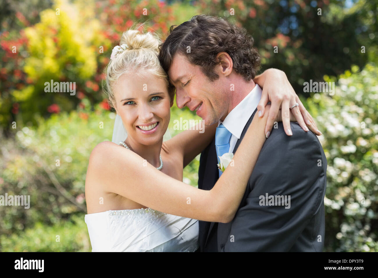 Husband hugging his new wife smiling at camera Stock Photo - Alamy