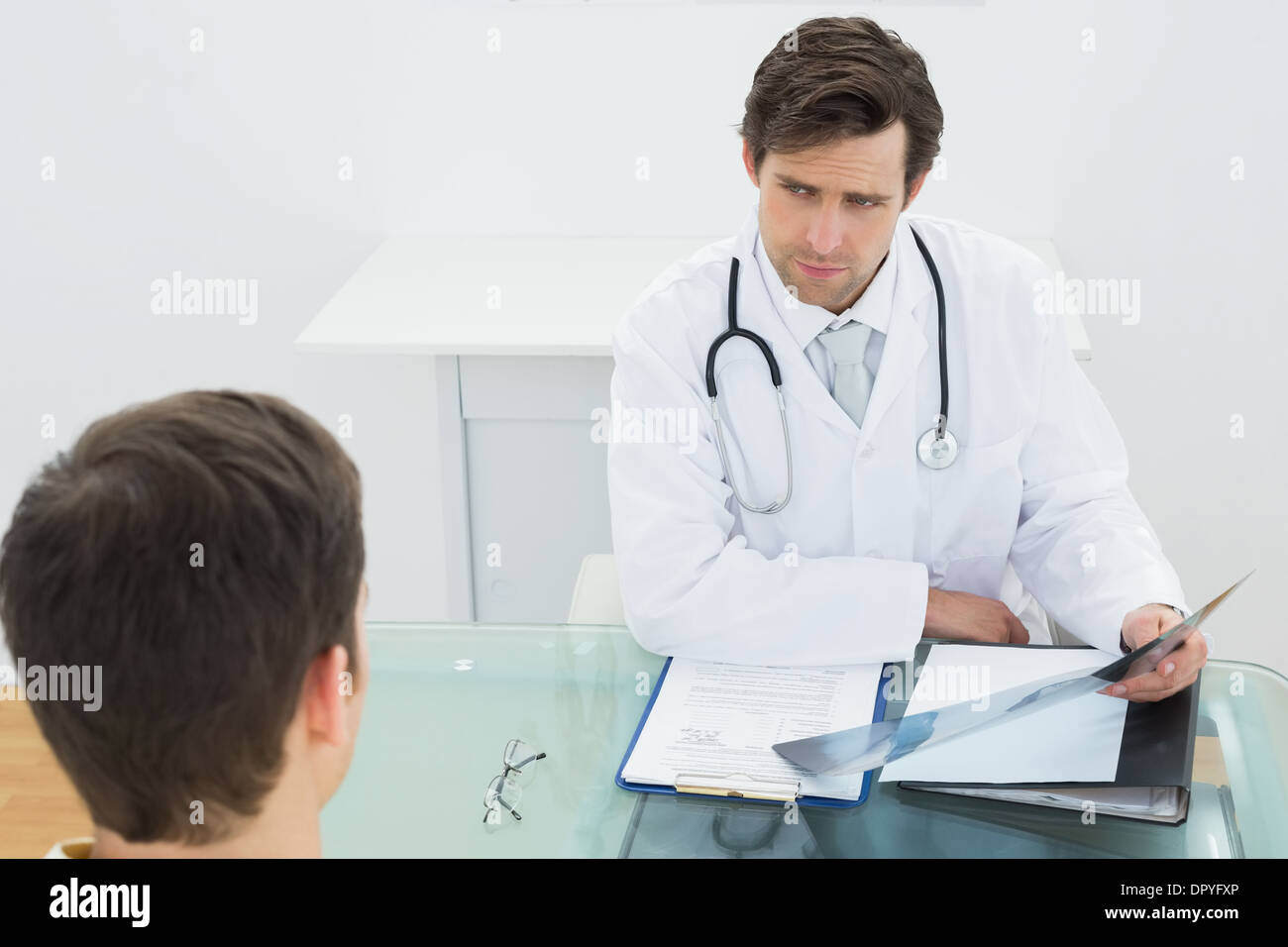 Doctor explaining x-ray reports to patient in office Stock Photo - Alamy