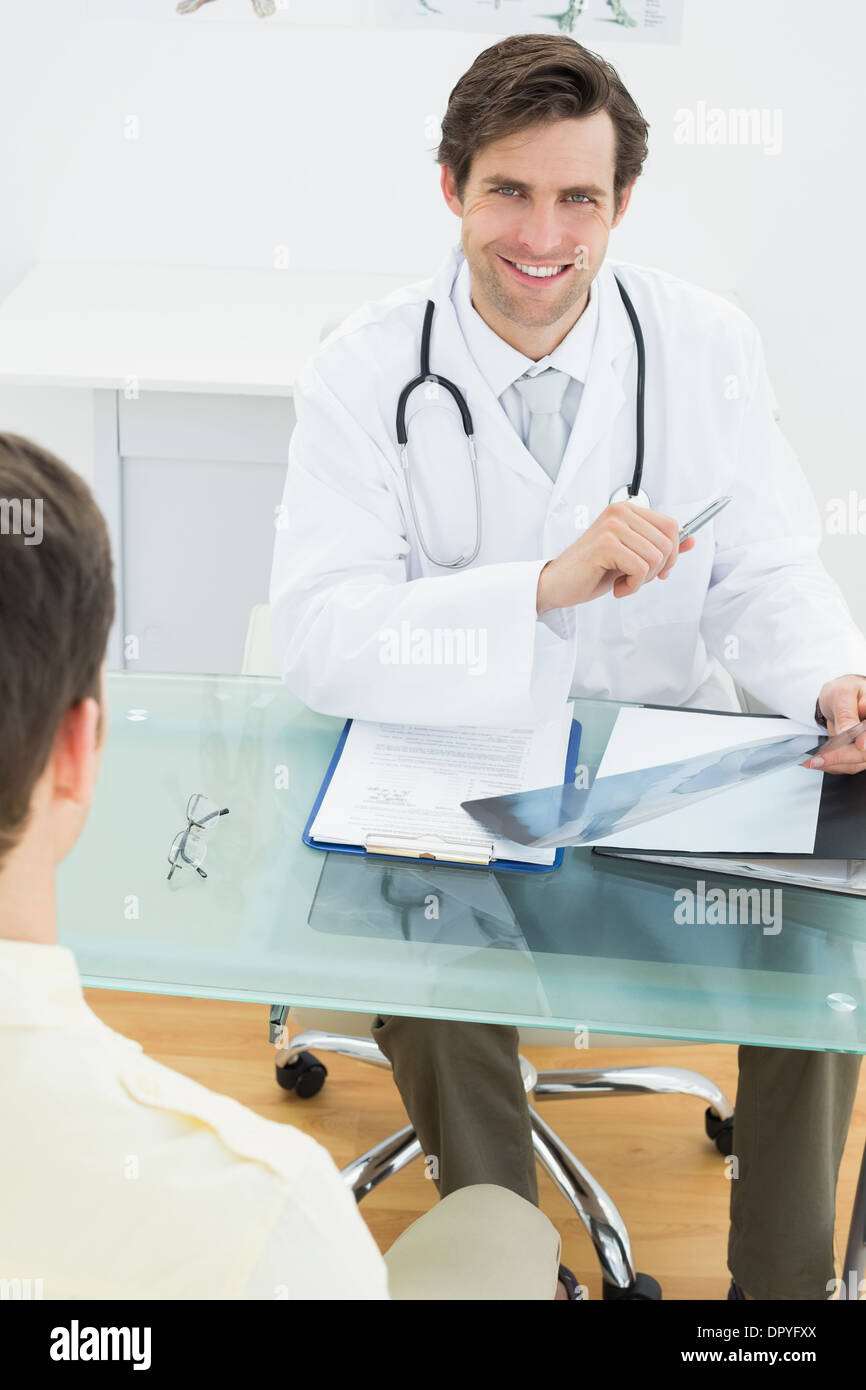Smiling doctor explaining x-ray reports to patient Stock Photo - Alamy