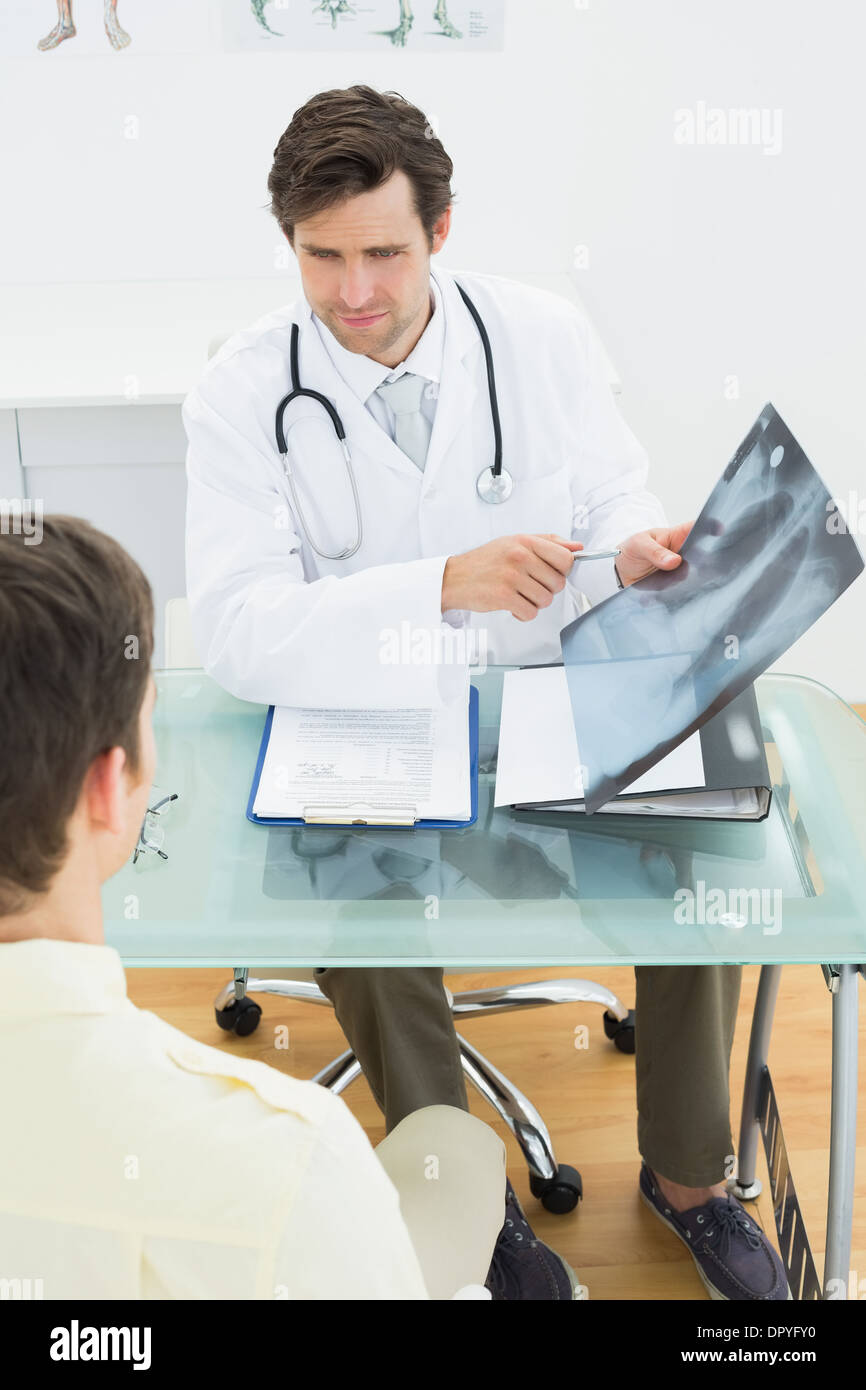 Doctor explaining x-ray reports to patient in office Stock Photo - Alamy