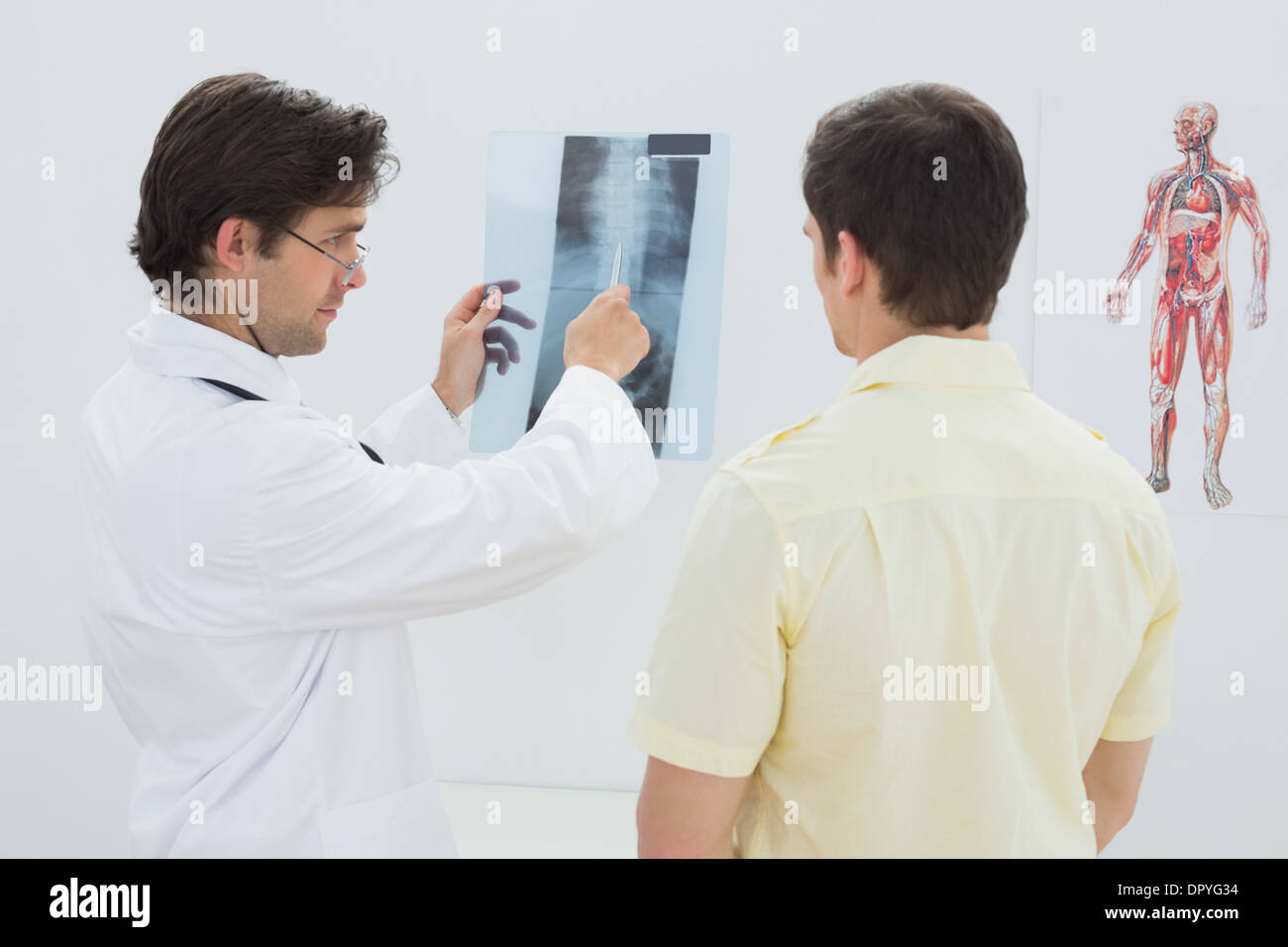 Male doctor explaining spine x-ray to patient Stock Photo - Alamy