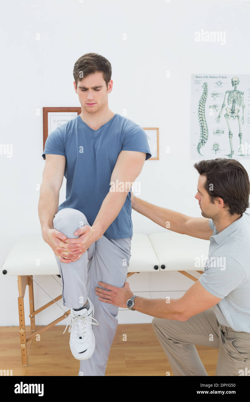 Male therapist assisting man with stretching exercises Stock Photo - Alamy