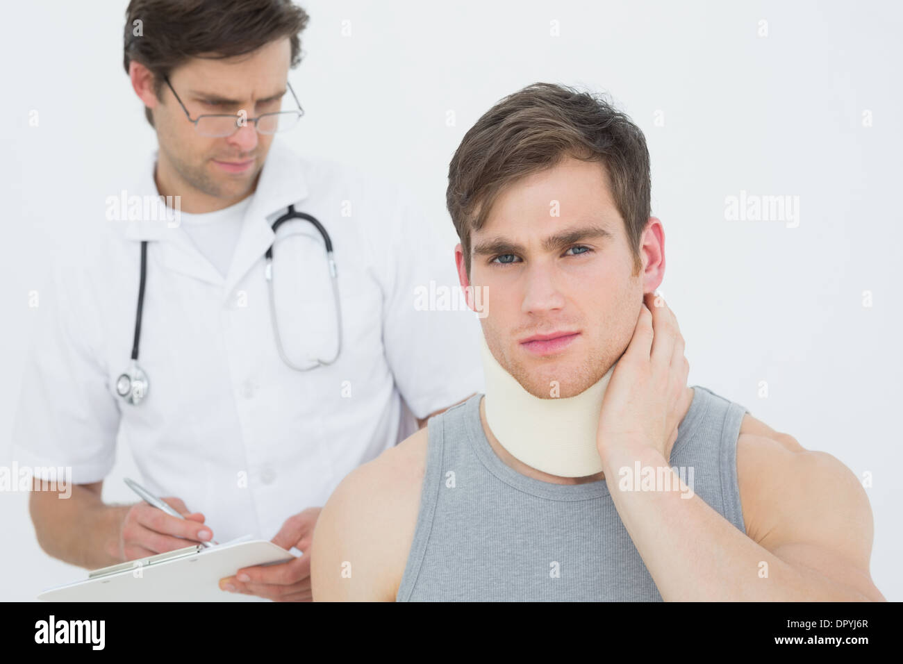Male doctor examining a patients neck Stock Photo - Alamy