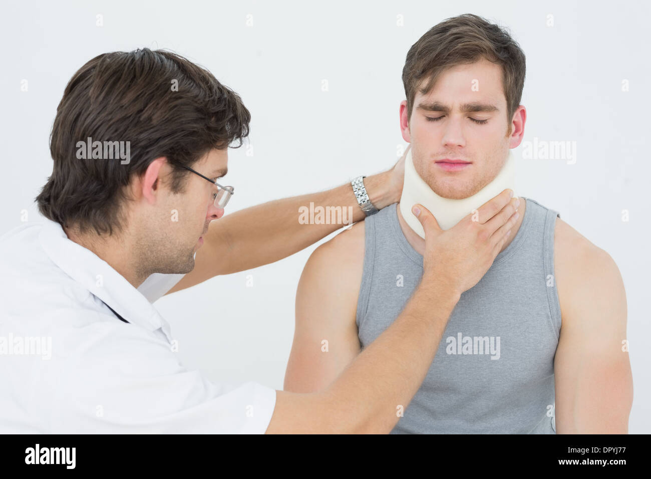 Male doctor examining a patients neck Stock Photo - Alamy