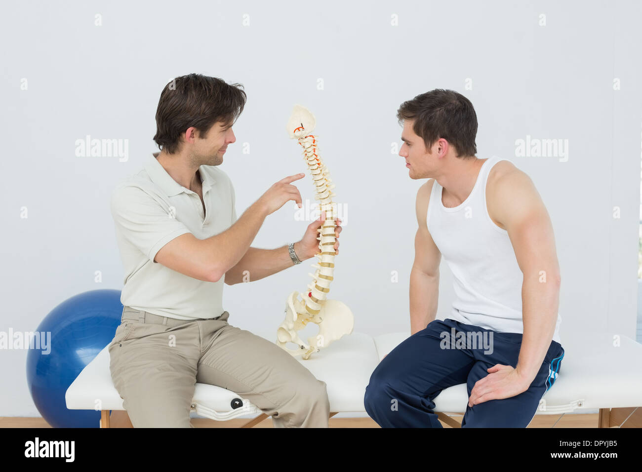 Physiotherapist showing patient something on skeleton model Stock Photo ...