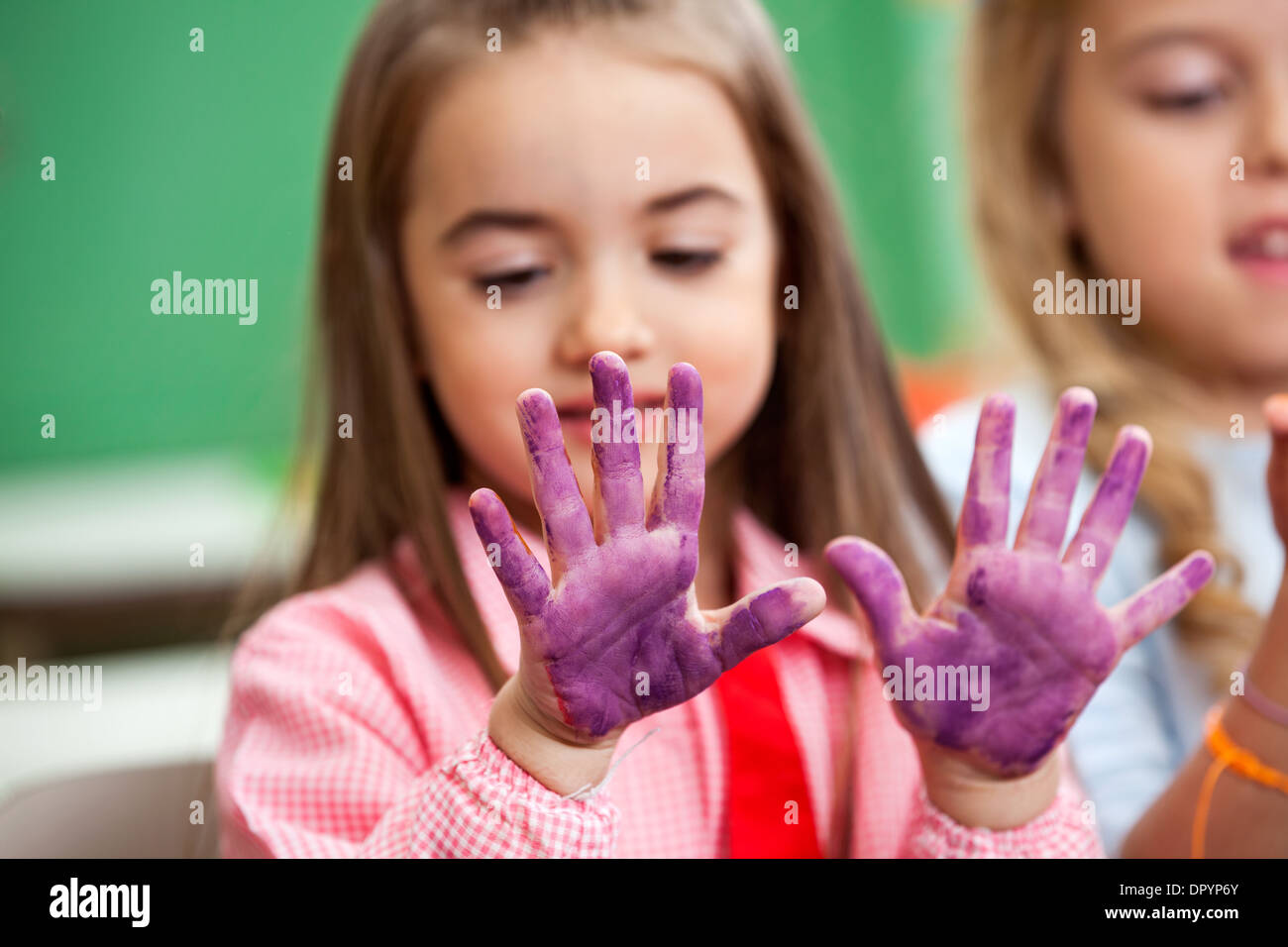 Girl Looking At Colored Hands In Art Class Stock Photo - Alamy