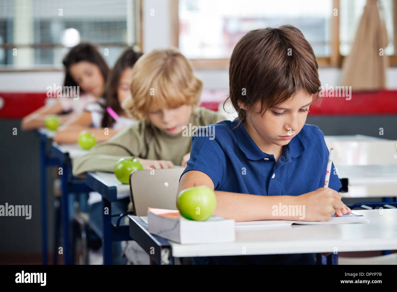 Boy Studying At Desk In Classroom Stock Photo - Alamy