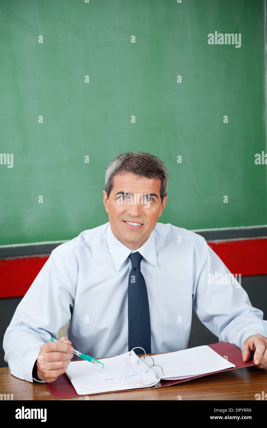 Portrait happy professor sitting desk hi-res stock photography and ...