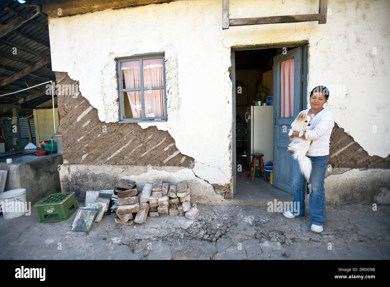 Arelis de Leon, 37, stands outside of her house in San Marcos damaged ...