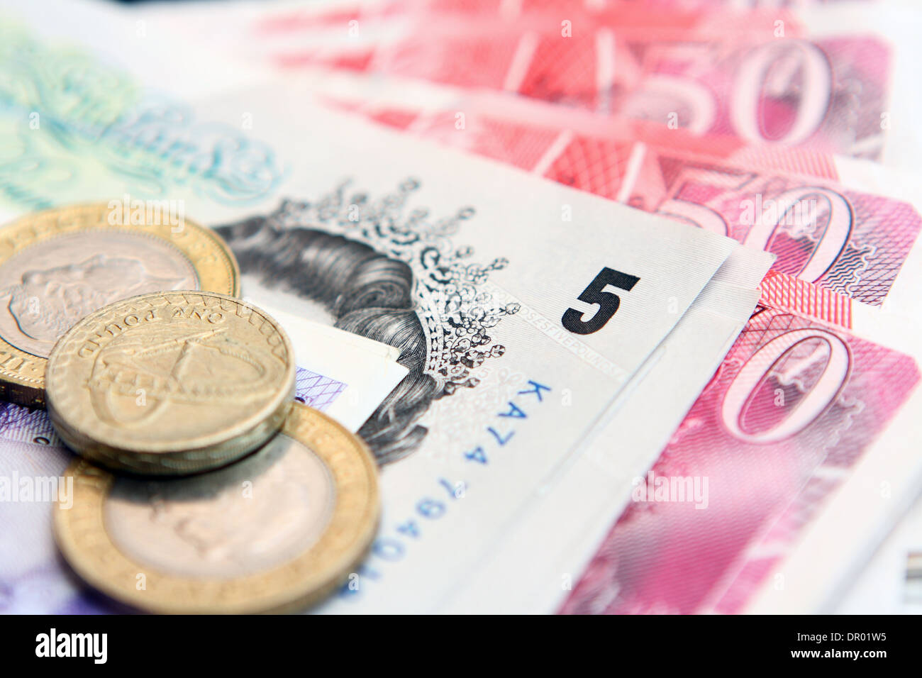 Sterling notes and coins - £50, £20 and £5 notes underneath £2 and £1 ...