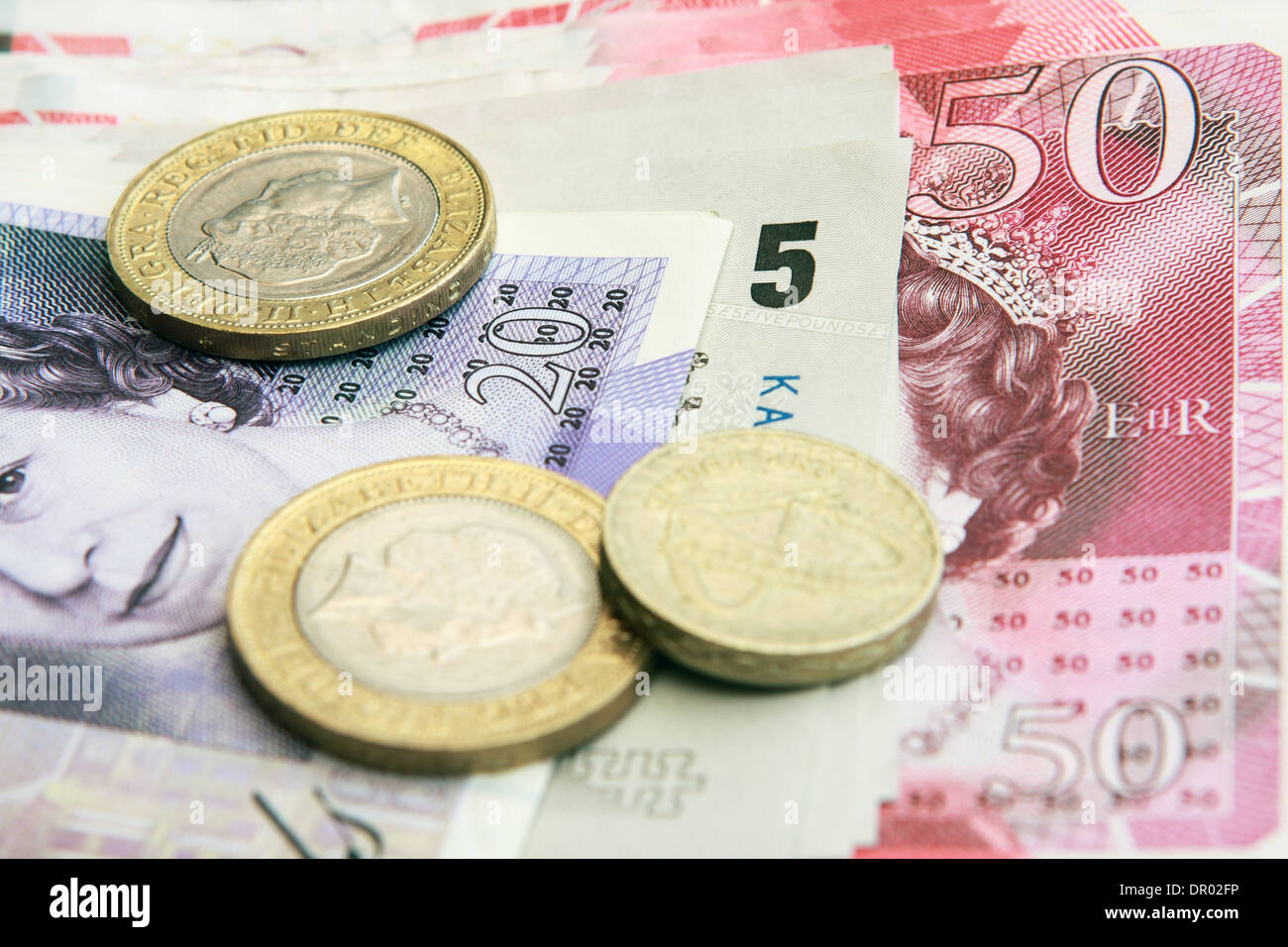 Sterling notes and coins - £50, £20 and £5 notes underneath £2 and £1 ...