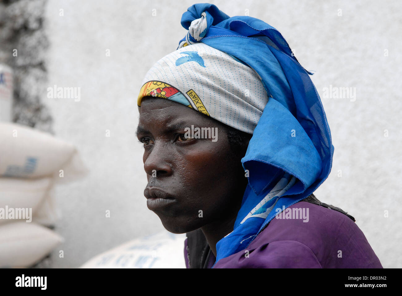 A displaced Congolese woman looks dejected as she waits for food ...