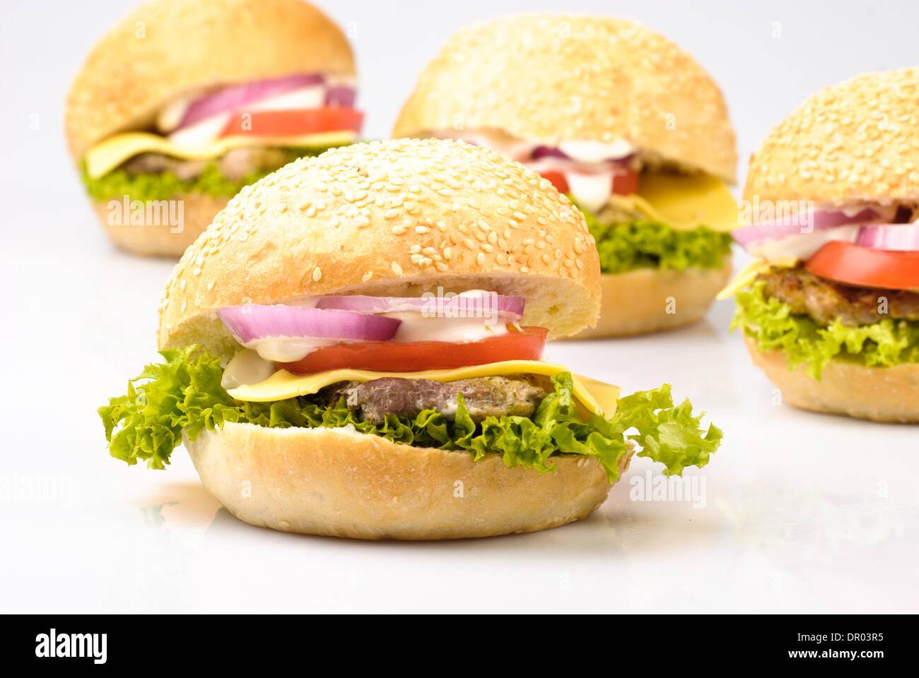 four homemade hamburgers isolated on white background Stock Photo - Alamy
