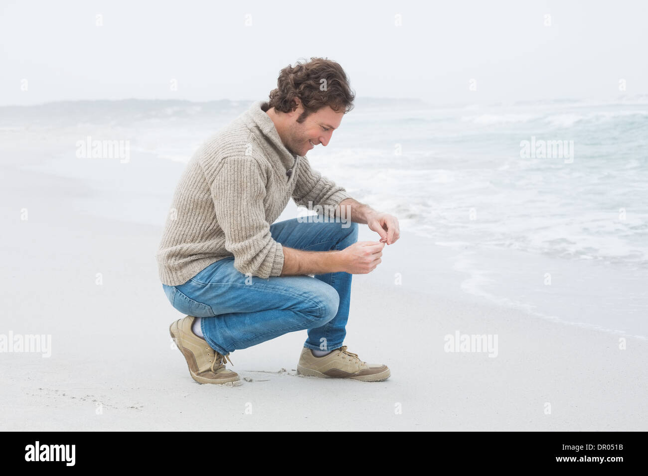 Side view of a casual young man relaxing at beach Stock Photo - Alamy