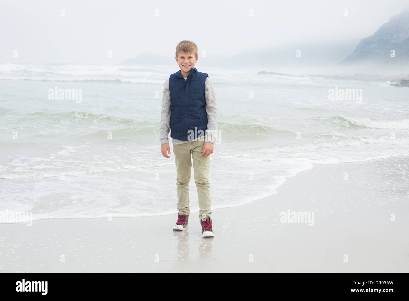 Full length of a cute smiling boy at beach Stock Photo - Alamy