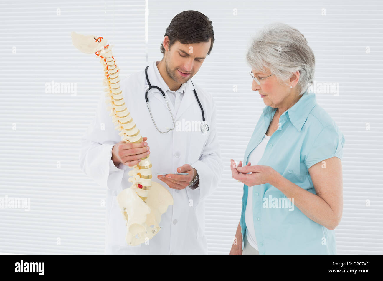 Male doctor explaining the spine to a senior patient Stock Photo - Alamy