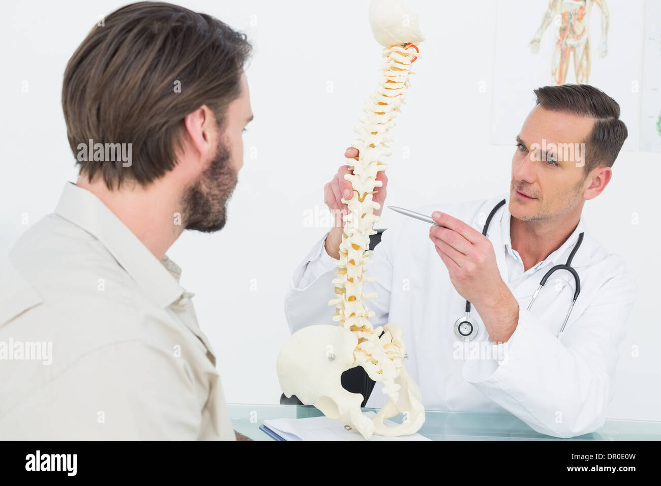 Male doctor explaining the spine to a patient Stock Photo - Alamy