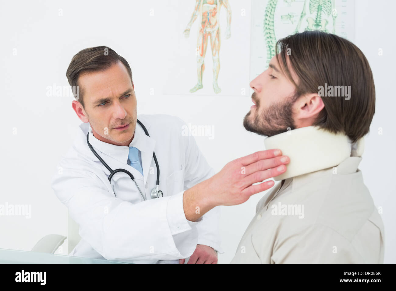 Male doctor examining a patient's neck Stock Photo - Alamy