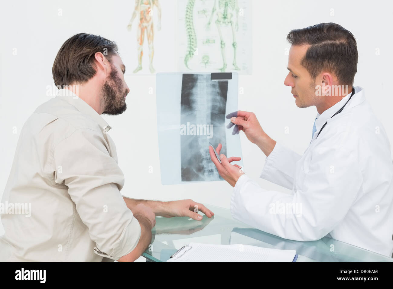 Male doctor explaining spine x-ray to patient Stock Photo - Alamy
