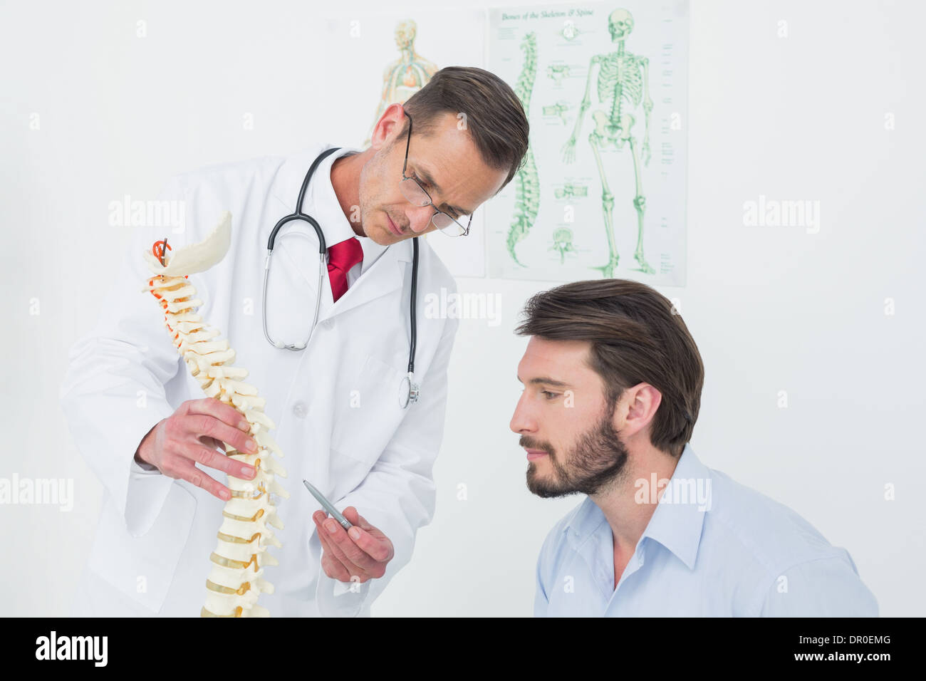 Male doctor explaining the spine to a patient Stock Photo - Alamy