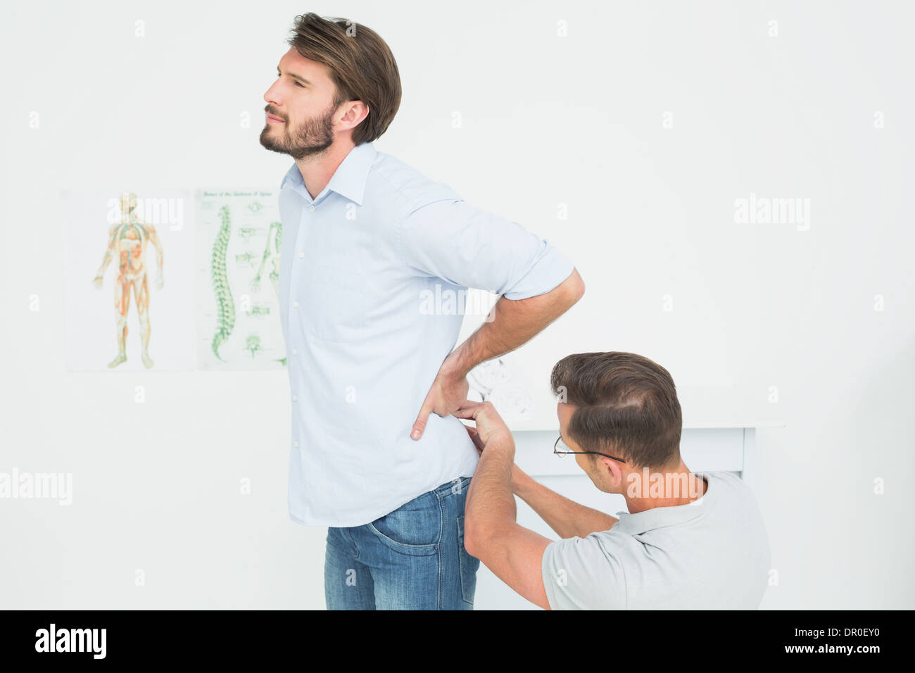 Male physiotherapist examining man's back Stock Photo - Alamy