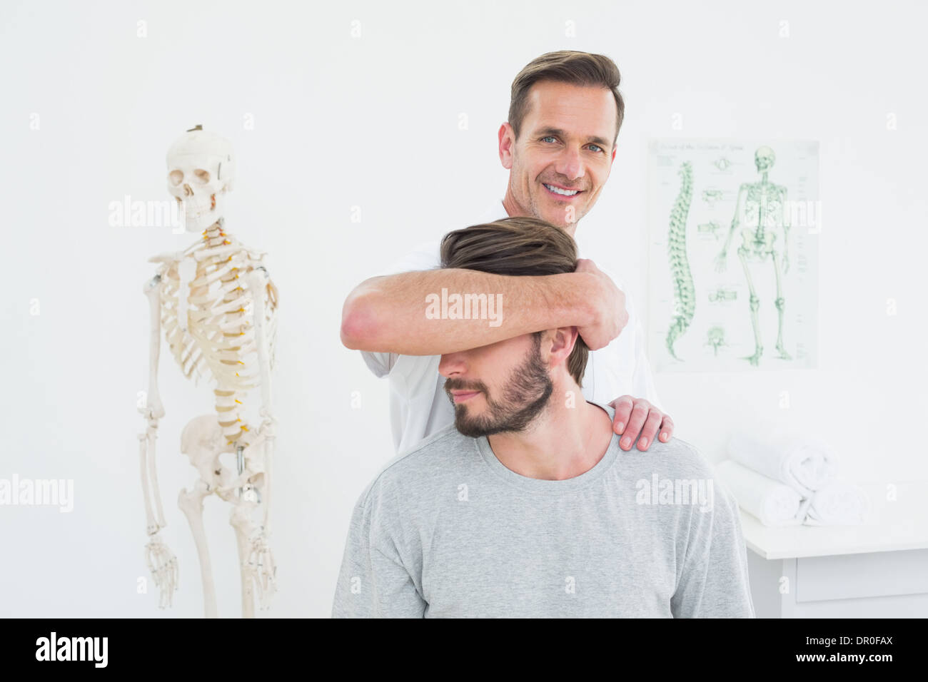 Portrait of a male chiropractor doing neck adjustment Stock Photo - Alamy