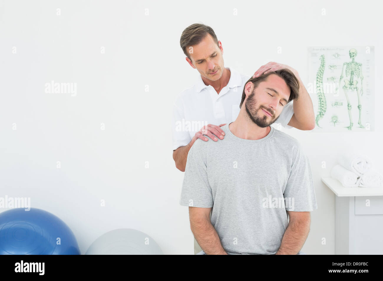 Male chiropractor doing neck adjustment Stock Photo - Alamy
