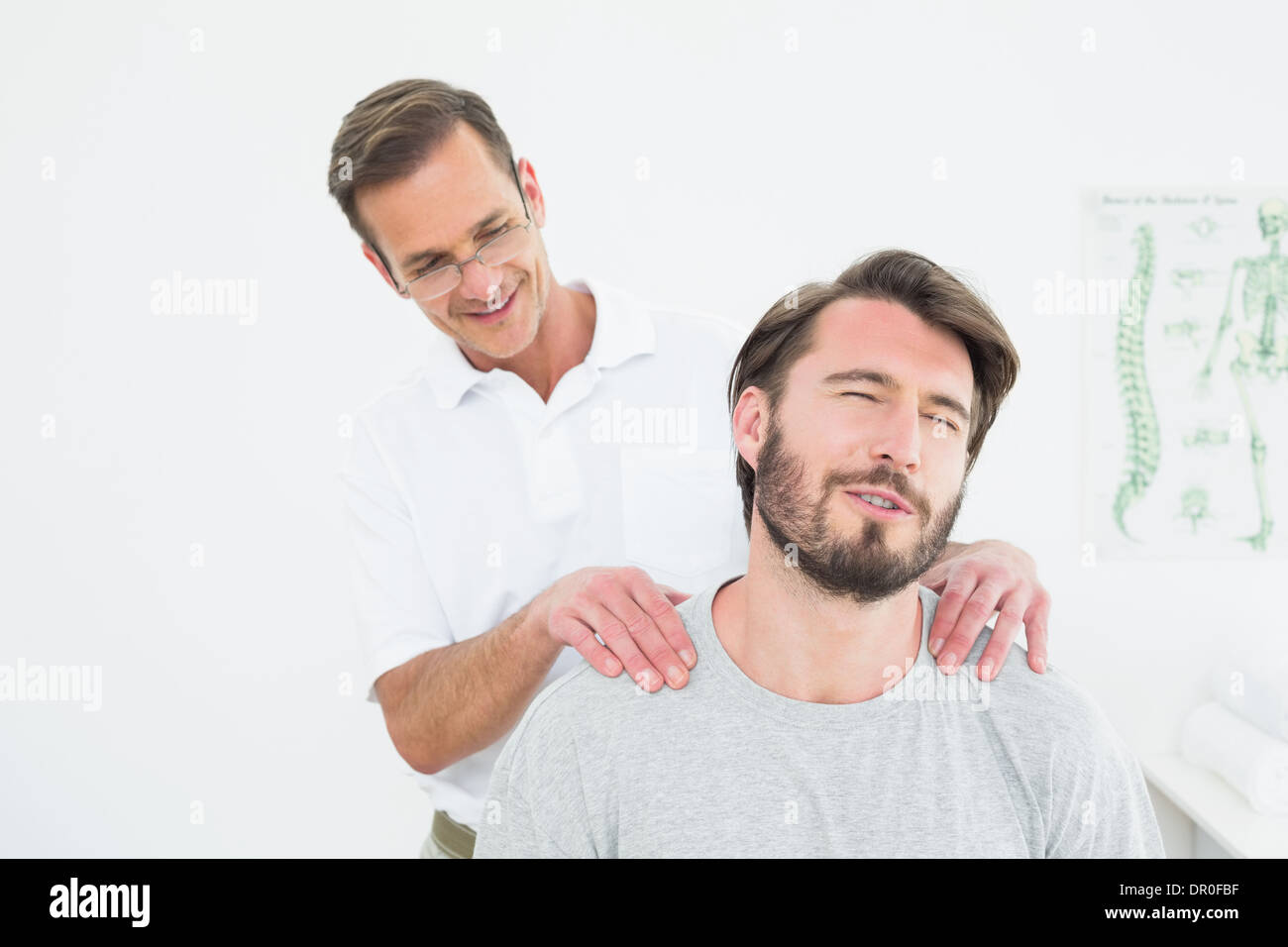 Male therapist massaging a content man's shoulders Stock Photo - Alamy