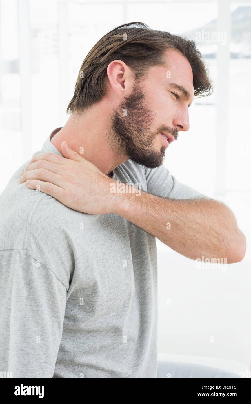 Young man suffering from shoulder pain Stock Photo - Alamy